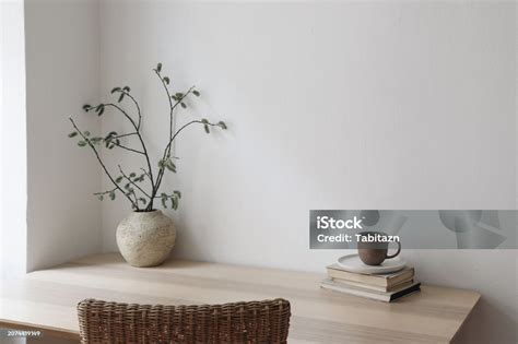 스칸디나비아 거실 인테리어 커피 한 잔 나무 테이블에 책 버드 나무 가지 꽃병에 캣킨 등나무 의자 우아한 스칸디 업무 공간 홈 오피스 빈 베이지색 벽 배경 0명에 대한 스톡