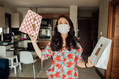얼굴에 얼굴 마스크를 가진 여자는 그녀의 손에 두 개의 선물 상자를 들고 생일에 대한 스톡 사진 및 기타 이미지 생일 은퇴 팬데믹 질병 Istock