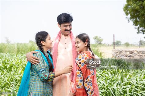 행복한 인도 농부 아버지는 농업 분야에서 사랑과 지원 작은 가족 시골 인도를 보여주는 두 어린 사랑스러운 딸을 껴안습니다 콧수염 남자는 아름다운 소녀들과 웃고 있다 10