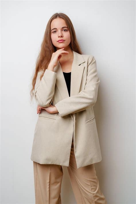 Young Woman Model Posing In Beige Suit Against White Background Stock