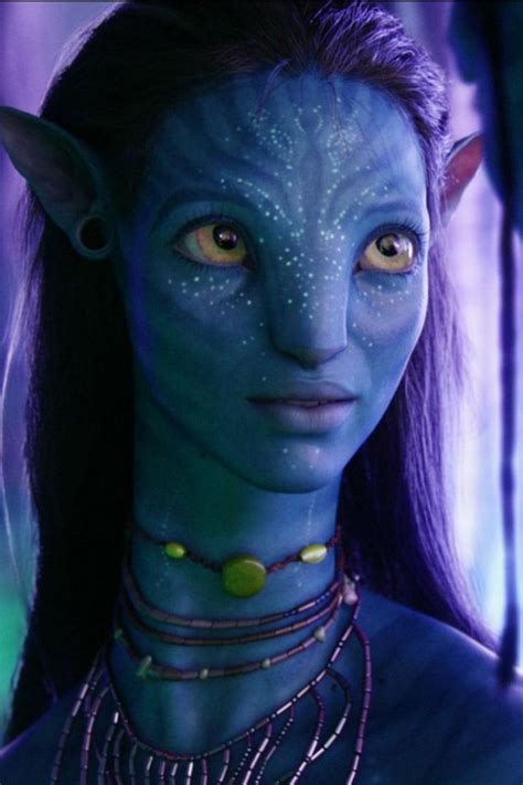 A Close Up Of A Person With Blue Skin And Green Eyes Wearing Necklaces