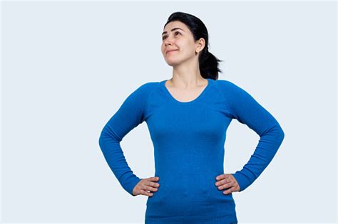 흰색 배경을 통해 자신감 여자 미소 흰색 배경 위에 고립 된 슈퍼 히어로처럼 가슴과 힘을 보여주는 엉덩이에 주먹을 쥔 강하고 단호하고 자신감있는 여성 사람들은 자신감 표현