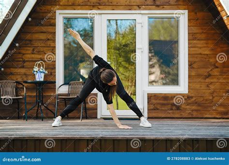 Athletic Woman Performs Bends And Spreads Her Arms To Sides During Morning Workout Stock Image