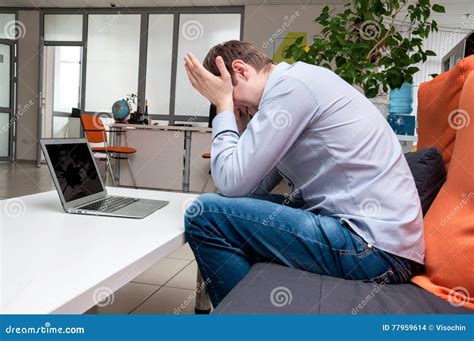 Молодой красивый человек с компьютером в офисе Стоковое Фото изображение насчитывающей