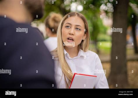 Young Blonde And Beautiful College Student Talking To Her Classmate