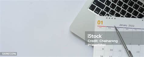 작업 및 생활 개념을 계획하기 위한 흰색 배경의 시간표를 충족하거나 관리하기 위해 사무실에서 노트북으로 캘린더 2022 개월 일정에 대한 상단 보기를 닫습니다 2022년에