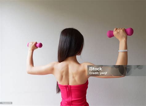 보디 빌딩 아령과 함께 운동하는 강한 핏의 여성 분홍색 섹시한 스포츠웨어 리프팅 역도 및 팔에 대 한 운동을 하 고 근육 아시아 여자 흰색 배경에 백 뷰 스튜디오 촬영 20