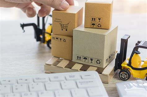 미니 지게차 트럭은 나무 팔레트에 기호와 손가락 근처와 키보드에 골판지 상자를로드합니다 물류 및 운송 관리 아이디어 및 산업 비즈니스 상업 개념 고객에 대한 스톡 사진 및