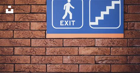 파란색과 흰색 출구 간판은 갈색 벽돌 벽에 장착되었습니다 사진 Unsplash의 무료 출구 이미지