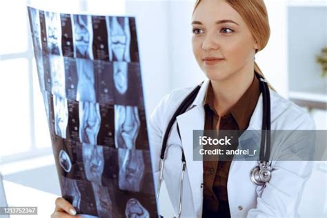 병원에서 창 근처 엑스레이 사진을 검사 하는 의사 여자 직장에서 외과 의사 또는 정형 외과 의사 의학 및 의료 개념 카키 색 블라우스 의 A 테라피스트 외모 좋아 X 레이에