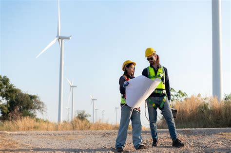 Premium Photo Engineer And Worker Discussing On A Wind Turbine Farm