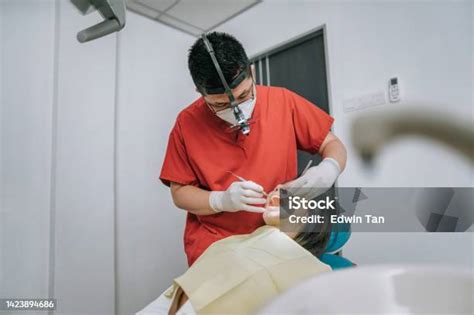 돋보기를 착용한 아시아 중국 남성 치과의사가 치과의사 사무실에서 여성 환자를 검사합니다 환자에 대한 스톡 사진 및 기타 이미지 환자 냅킨 치과 의사 Istock