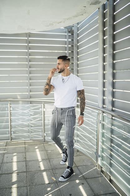 Premium Photo Hot Tattooed Man Wearing A White T Shirt And Gray