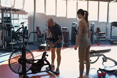피트니스 트레이너는 체육관에서 젊은 여성을위한 운동 자전거를 설정 스톡 사진 자전거 운동에 대한 스톡 사진 및 기타 이미지 자전거 운동 2명 30 34세 Istock