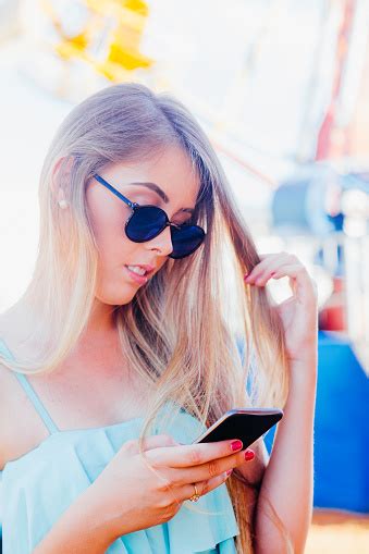젊고 예쁜 여 자가 모바일 장치를 보고 놀이 공원에서 그녀의 머리를 떨 려 고 라이프 스타일의 사진 가까운에 대한 스톡 사진 및 기타 이미지 Istock