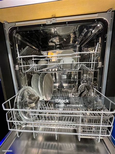 플라스틱이 든 식기 세척기의 내부 이미지 깨끗한 스테인레스 스틸 나이프 포크 및 숟가락이 들어있는 식기 바구니 씻고 말린 후 버릴 수있는 깨끗한 도구가있는 반 전체 기계