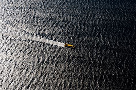 흔적을 남기고 푸른 물 위를 항해하는 노란 배의 공중 꼭대기 전망 0명에 대한 스톡 사진 및 기타 이미지 0명 노랑 돛 Istock