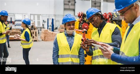 Multiracial Engineers Working Inside Robotic Factory Technology