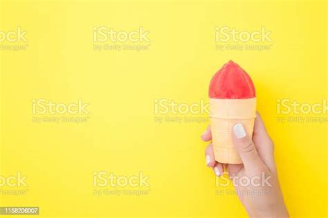 밝은 노란색 배경에 와플 컵에 분홍색 유약 아이스크림을 들고 젊은 여성 손 텍스트 따옴표 또는 속담을위한 빈 장소 근접 촬영 맨 위 보기 손에 대한 스톡 사진 및 기타
