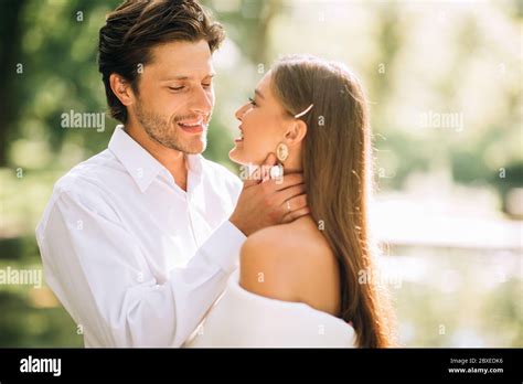 Newlyweds Couple Hugging Before Kiss At Wedding Ceremony In Park Stock