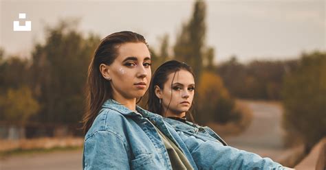 낮 동안 갈색 나무 다리에 서 있는 파란색 데님 재킷을 입은 여자 사진 Unsplash의 무료 난간 이미지