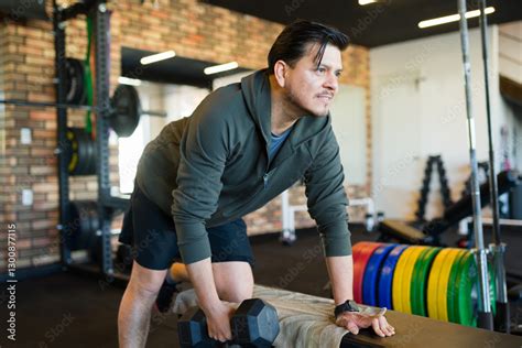 Overweight Male Performing Bicep Curls Using Free Weights During