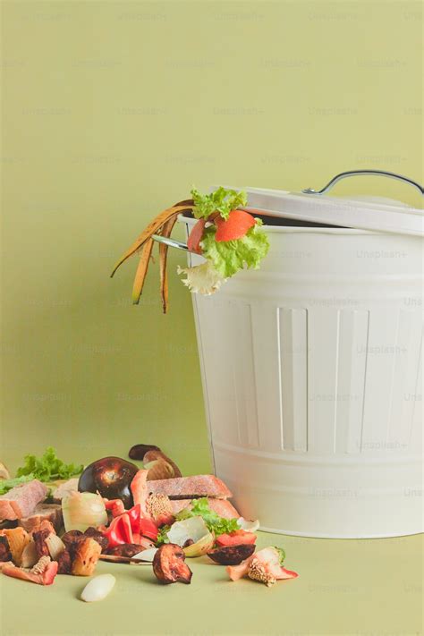 음식물 더미 옆에 놓인 하얀 쓰레기통 사진 Unsplash의 낭비 이미지