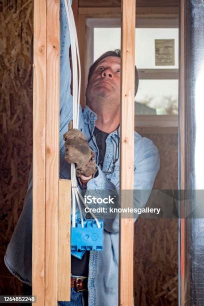 전기 기술자가 벽에 있는 전기 상자에 와이어를 당깁니다 가정용 장비에 대한 스톡 사진 및 기타 이미지 가정용 장비 남자 남자들만 Istock