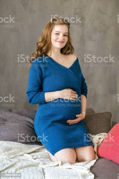 파란 바디콘 드레스를 입은 30주 임신한 여성이 하얀 벽에 머물러 있다 출산 휴가 임신 계획 출산 준비 부모에 대한 스톡 사진 및 기타 이미지 Istock