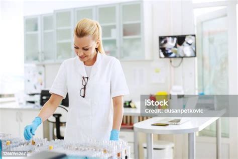 실험실에 서있는 동안 혈액 샘플테스트 튜브를 복용에 고무 장갑멸 제복을 입고 미소 여성 실험실 조수를 경험 Dna에 대한 스톡 사진 및 기타 이미지 Istock