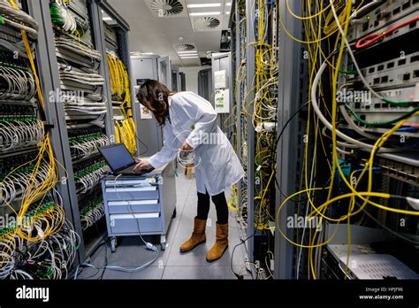 Female Engineer On Laptop Fixing Some Problems In A Server Room Stock Photo Alamy