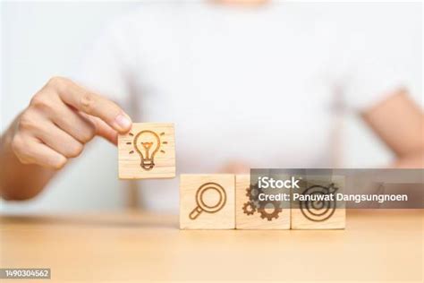 다트판 위에 전구를 들고 있는 여자의 손 기어 돋보기 아이콘 블록 사고 사업 계획 프로세스 목표 전략 목표 사명 행동 연구 팀워크 및 아이디어 개념 개념에 대한 스톡 사진