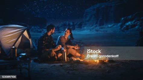 캐년에서 행복한 커플 자연 캠핑 캠프 파이어에 의해 앉아 커피를 마시고 밤 하늘을보고 여행하는 두 명의 젊은 이들이 이야기 은하수 별을 봐 영감 휴가 여행에 밤 하루
