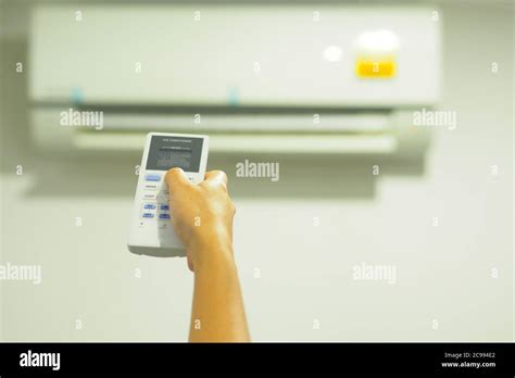 Woman Operating Remote Controller Air Conditioner With Remote Controller Stock Photo Alamy