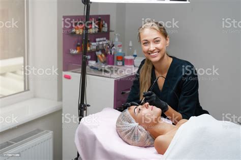 화장품 캐비닛 클라이언트는 소파에 누워있다 미용사는 눈썹에 표시를 적용합니다 페이셜 마스크에 대한 스톡 사진 및 기타 이미지 페이셜 마스크 2명 건강관리와 의술