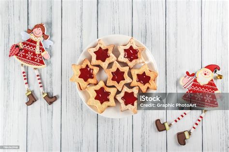 잼으로 채워진 수제 스타 쿠키의 상단보기는 소박한 흰색 나무 테이블에 접시에 배치 딸기 라즈베리 건포도 잼 쿠키 천사와 산타