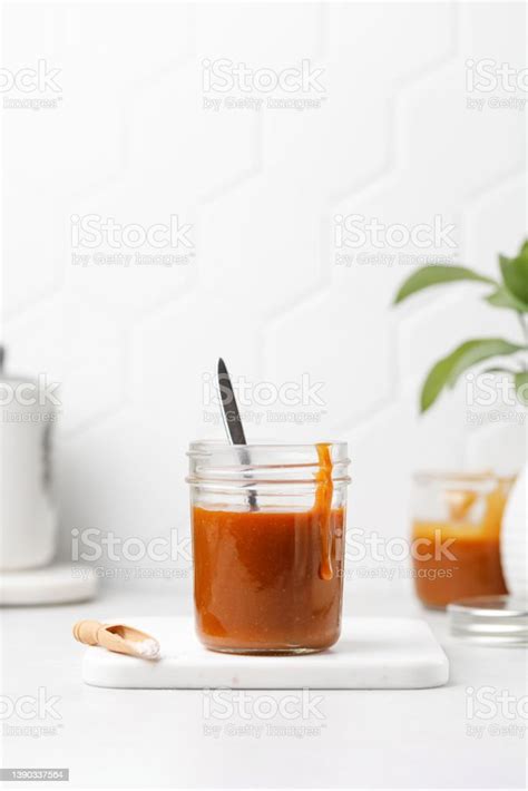 숟가락으로 항아리에 수제 캐러멜 화이트 보드에 소금에 절인 카라멜 소스 타일 배경 0명에 대한 스톡 사진 및 기타 이미지 0
