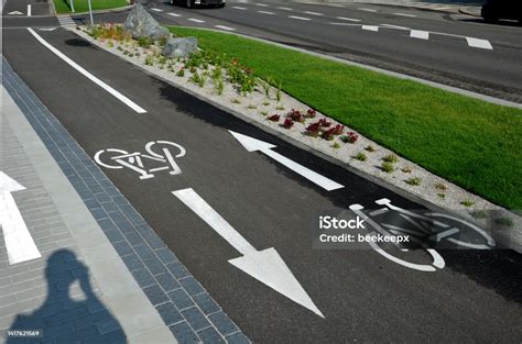 차선과 도로 사이에 섬이 나뉘어 보행자와 자전거 타는 사람들을위한 산책로 아스팔트에 페인트가 뿌려진 도로 표시 바퀴 화살표 및