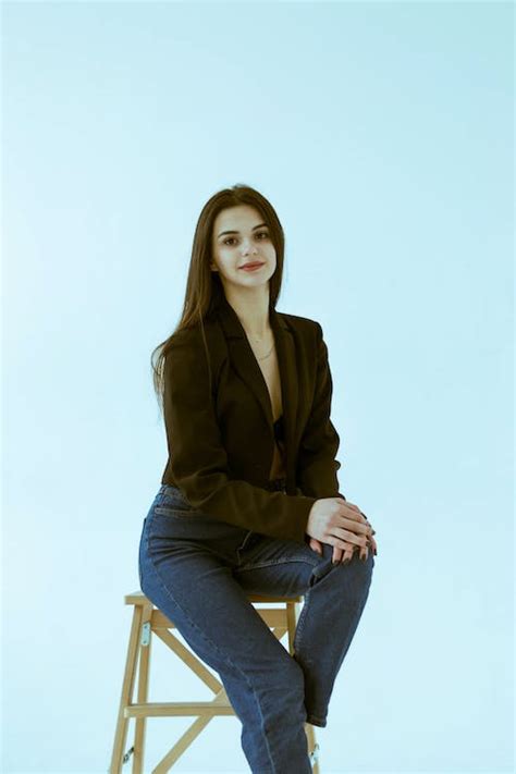 부츠 선글라스 수직 쐈어 수트 앉아 있는 여성 패션 사진 포즈를 취하는 회색 배경에 관한 무료 스톡 사진