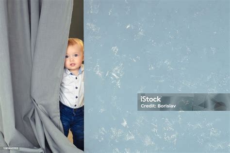 행복한 소년은 숨바꼭질을 하고 커튼 뒤에 숨어 있습니다 서리 벽 옆에 아름다운 금발 소년과 커튼 뒤에 숨어 2 3 살에 대한 스톡 사진 및 기타 이미지 Istock