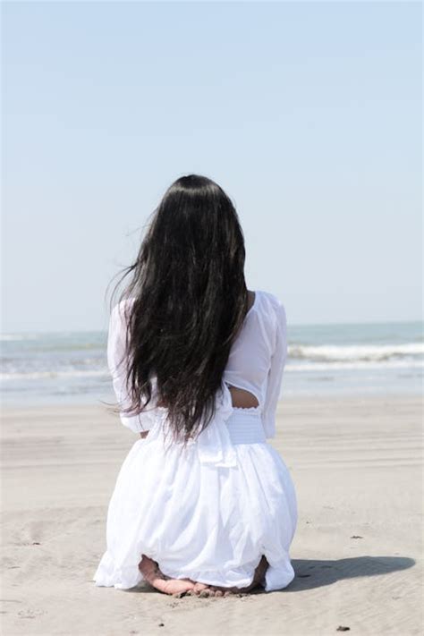 갈색 머리 격리 고요한 긴 머리 대낮 뒷모습 따뜻한 날씨 라이프스타일 레저 레크리에이션 모래 밀물과 썰물 바다 바다 경치 비치웨어 산들바람 손을