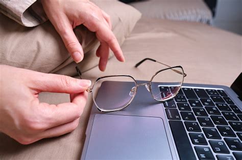 침대에서 안경을 쓰고 노트북으로 작업하는 젊은 여성 손에 시력을 위한 안경 클로즈업 재택 근무 가정 생활에 대한 스톡 사진 및 기타 이미지 Istock