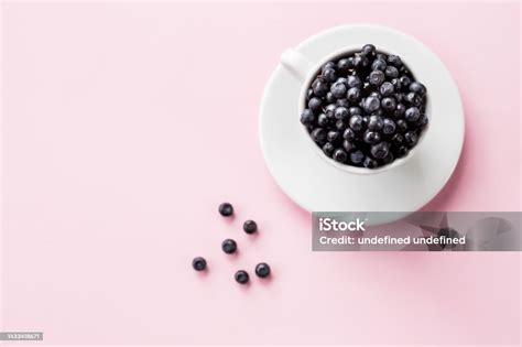 흰색 컵에 블루 베리 컬러 테이블에 육즙이 많고 신선한 블루베리가 있는 그릇 공간을 복사합니다 분홍색 배경에 신선한 딸기가 있는 머그잔 신선한 딸기 따기 0명에 대한 스톡