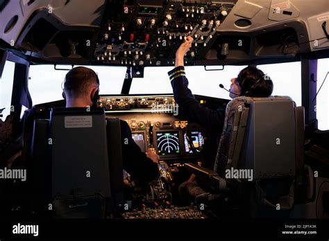 Captain And Female Copilot Getting Ready To Fly Plane And Takeoff With Dashboard Navigation In