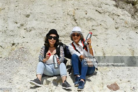 두 명의 은퇴한 친구 여행자가 배낭을 메고 바위 절벽 벽 앞에 앉아 있습니다 홀리데이 사람 및 야외 활동 개념 휴식에 대한 스톡 사진 및 기타 이미지 Istock