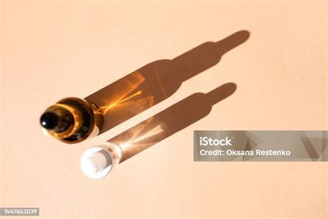 파스텔 베이지 표면의 연속으로 배열된 화장품 액체의 유리 병은 그림자를 캐스팅합니다 평평한 스타일 복사 공간 0명에 대한 스톡 사진 및 기타 이미지 Istock