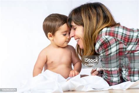 하얀 배경을 가진 스튜디오에서 아기 소년 그의 어머니와 함께 매우 흥미 진진하고 아름다운 순간에 앉아 8 개월 된 백인 2명에