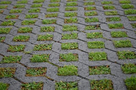 잔디가 있는 콘크리트 잔디 창살 회색 자연석으로 만든 사각형 타일의 배경 질감 도로의 콘크리트 가로 기하학적 포장 패턴 녹색 잔디 및 생태 주차장 녹색 주차 지속 가능한