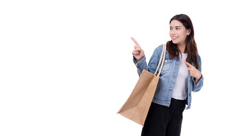 복사 공간을 가리키고 웃는 얼굴과 행복한 얼굴로 빈 공간을 바라보는 쇼핑 젊은 여성 예쁜 소녀는 만족스러운 제품처럼 행동하고