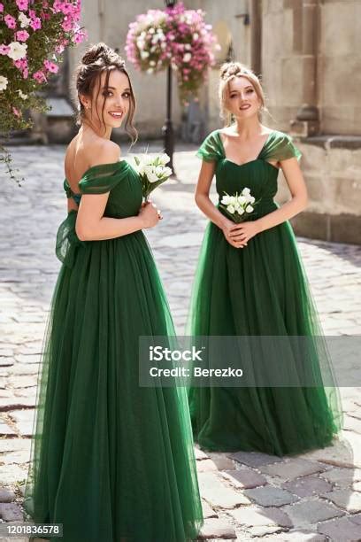 두 아름다운 신부 들러리 여자 금발과 갈색 머리 숙녀 우아한 전체 길이 오프 숄더 그린 쉬폰 신부 들러리 드레스와 들고 꽃다발을